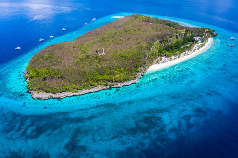 Aerial view of the Sumilon island, sandy beach with tourists swimming ...
